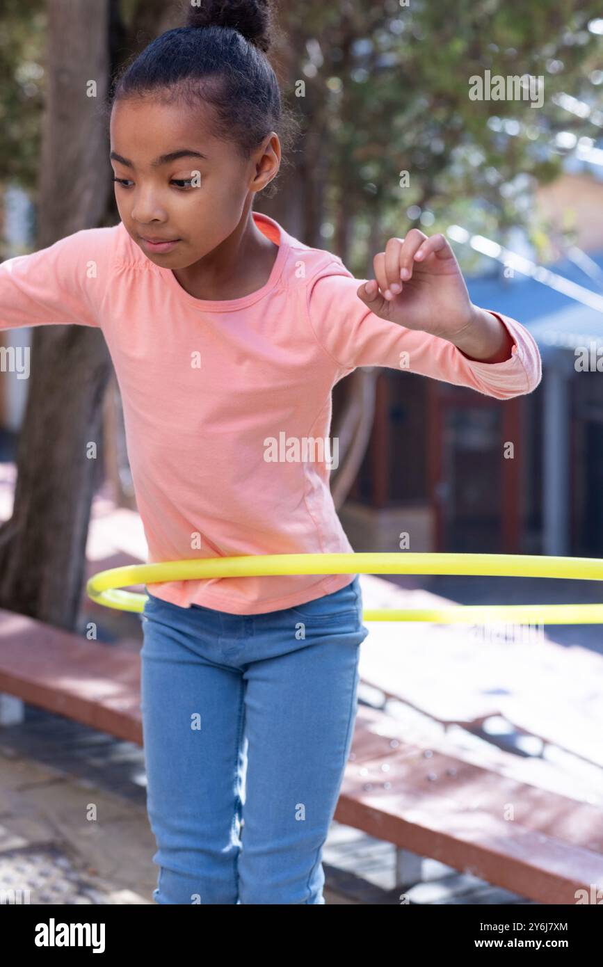 Playing with hula hoop, african american girl enjoying outdoor activity ...