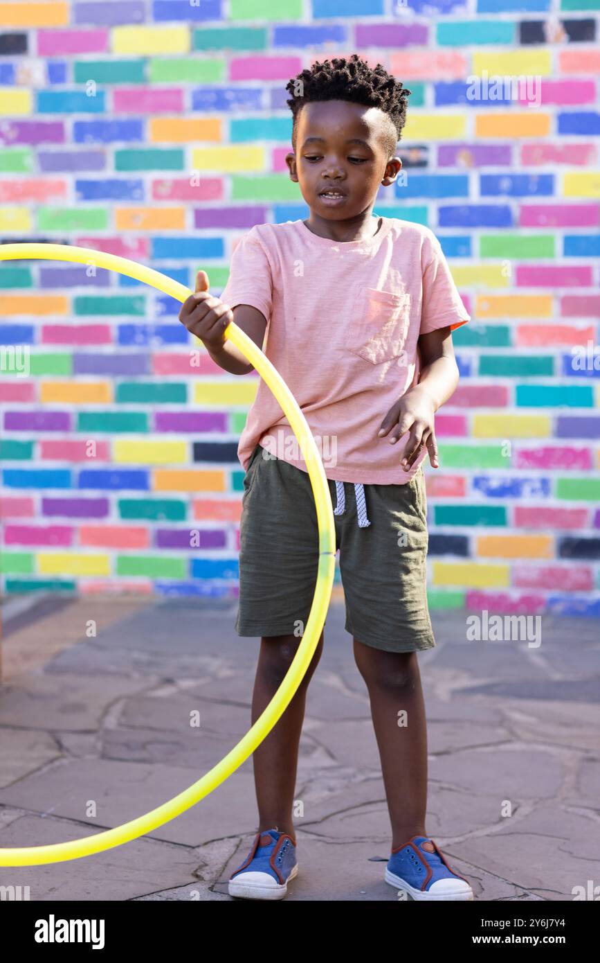Playing with hula hoop, african american boy enjoying outdoor activity ...