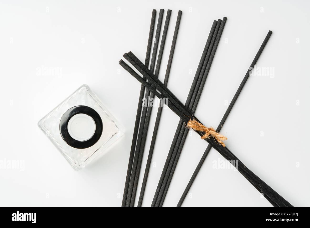 A minimalist display of essential oil and black diffuser sticks on a ...