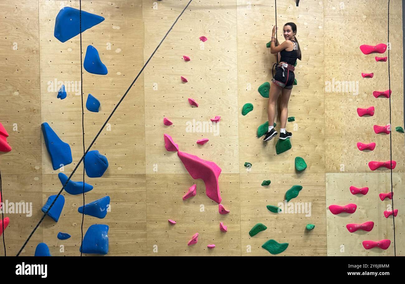 Teenage girl at indoor climbing wall. Kid having fun at bouldering wall ...
