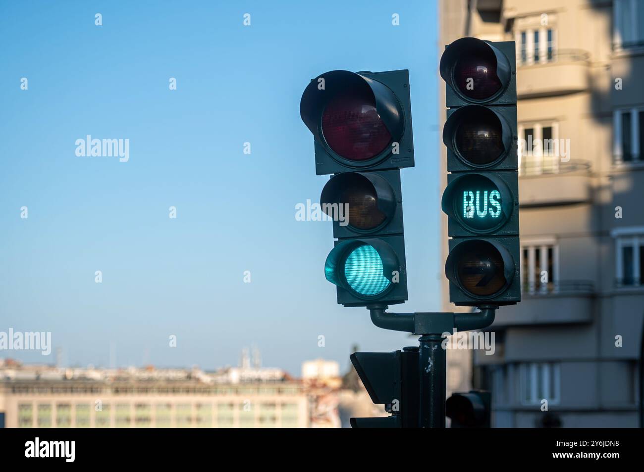 A green traffic light with a bus indicator illuminated in a bustling ...