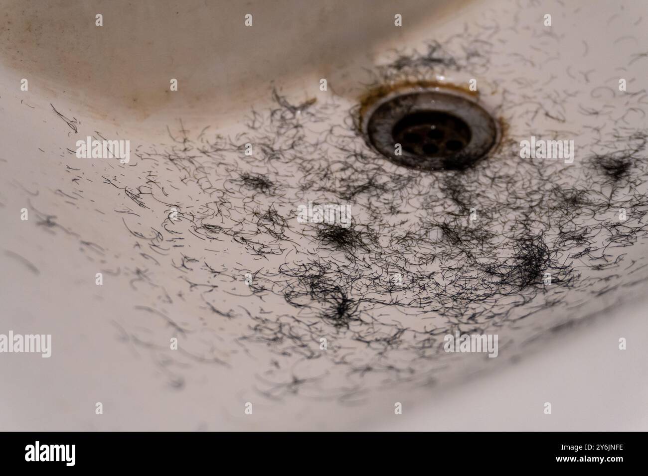 untidy ceramic sink covered with shaved hairs. Represents poor hygiene ...