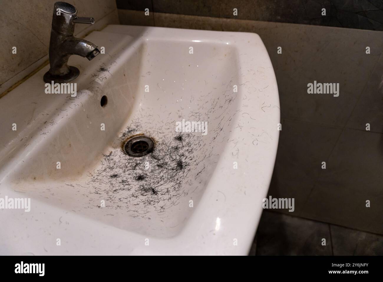 untidy ceramic sink covered with shaved hairs. Represents poor hygiene ...