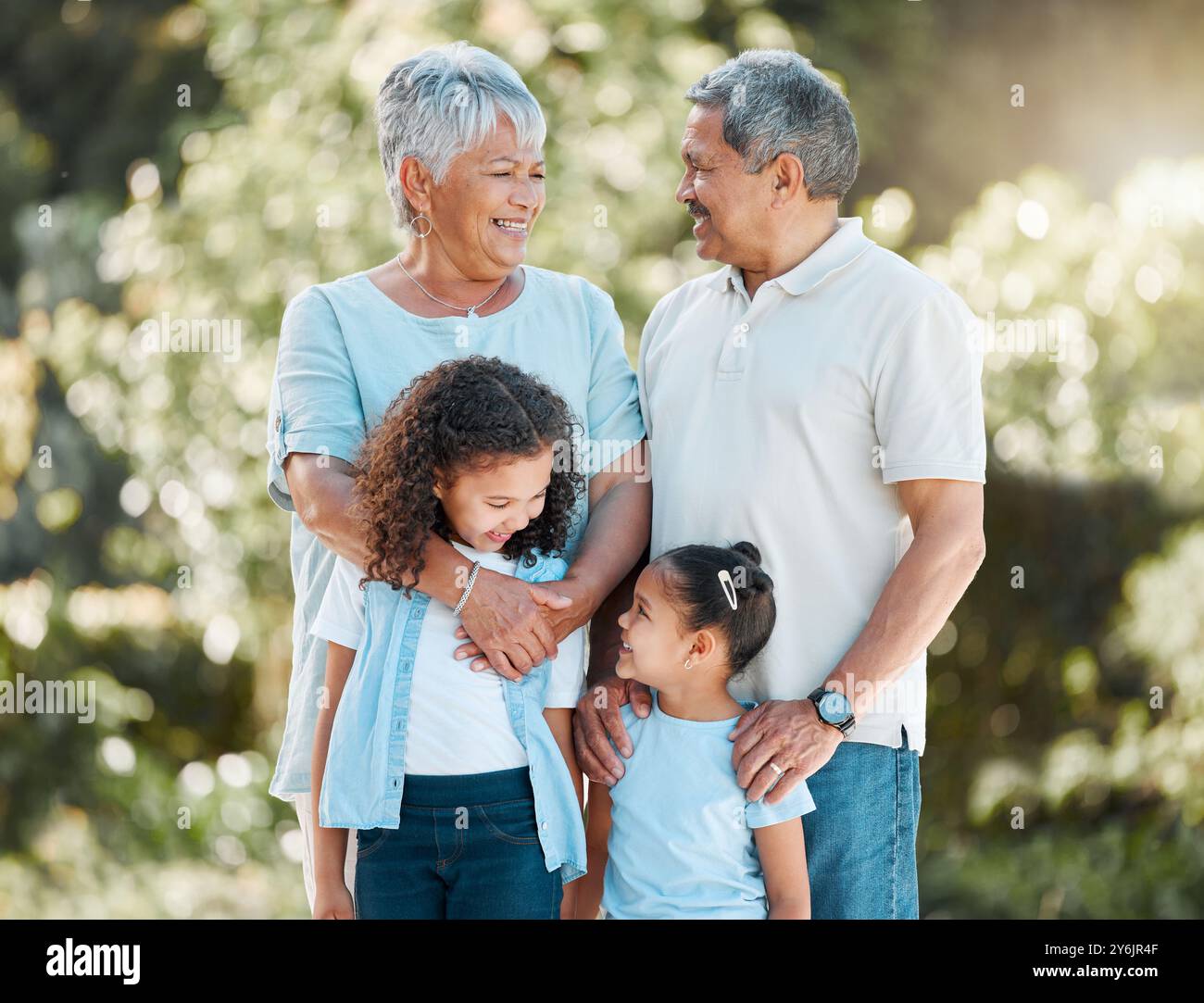 Family, grandparents and kids in garden for hug, happy memories and ...