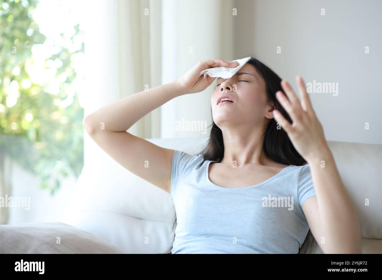 Stressed asian woman drying sweat with a tissue suffering heat stroke ...