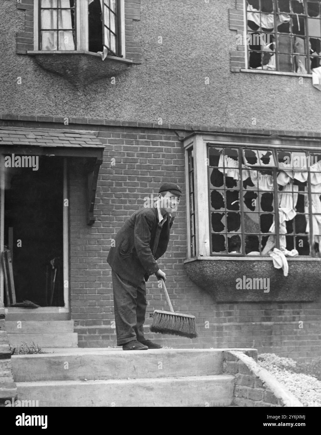 Schoolboy sweeping debris after his Gravesend home in Kent had been ...