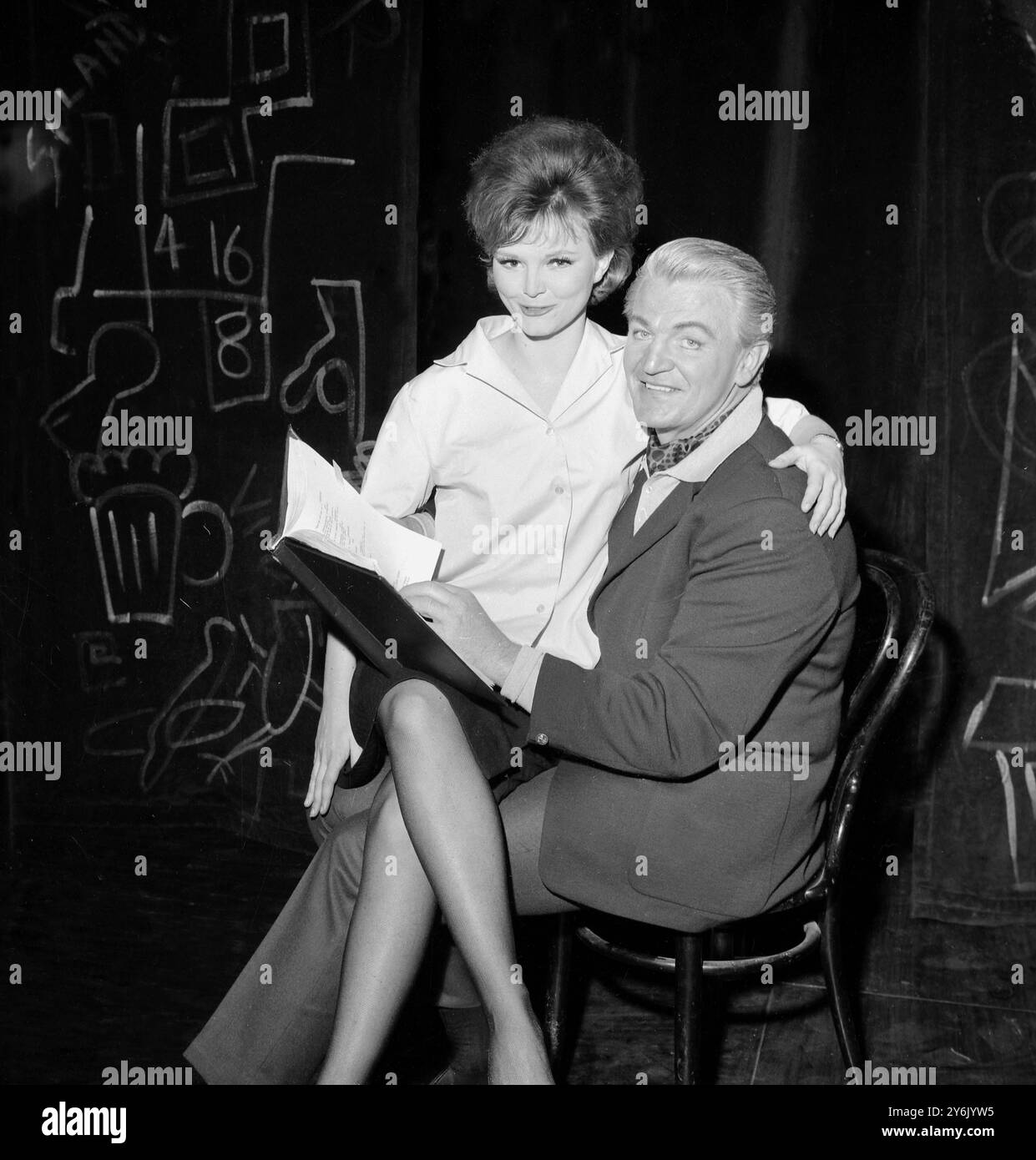 South African actress , Erica Rogers , perches herself on the knee of American actor , Art Lund ...