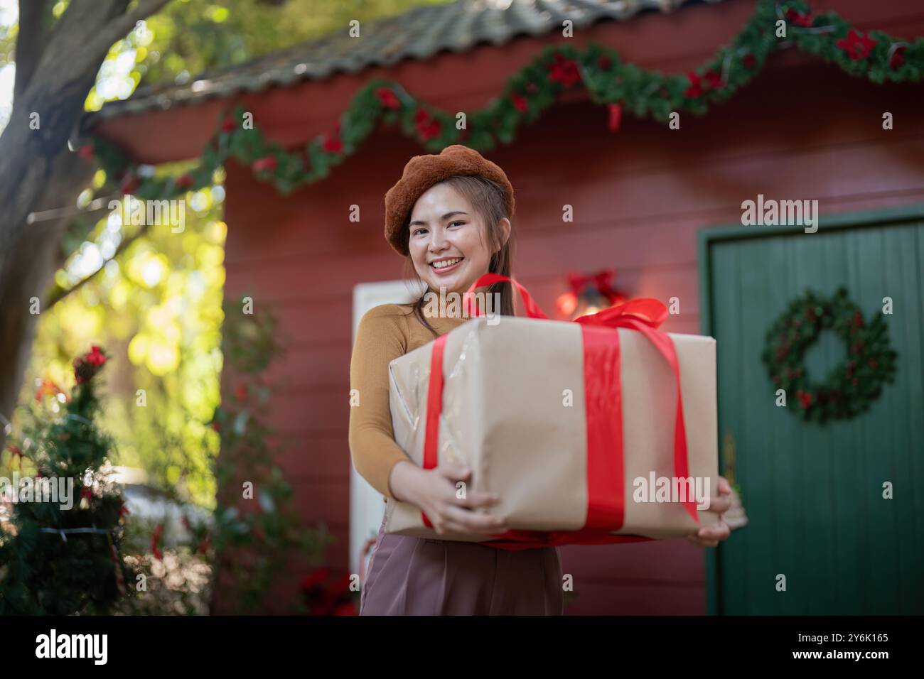 Holiday Cheer Young Woman Carrying Wrapped Gift with Joyful Expression ...
