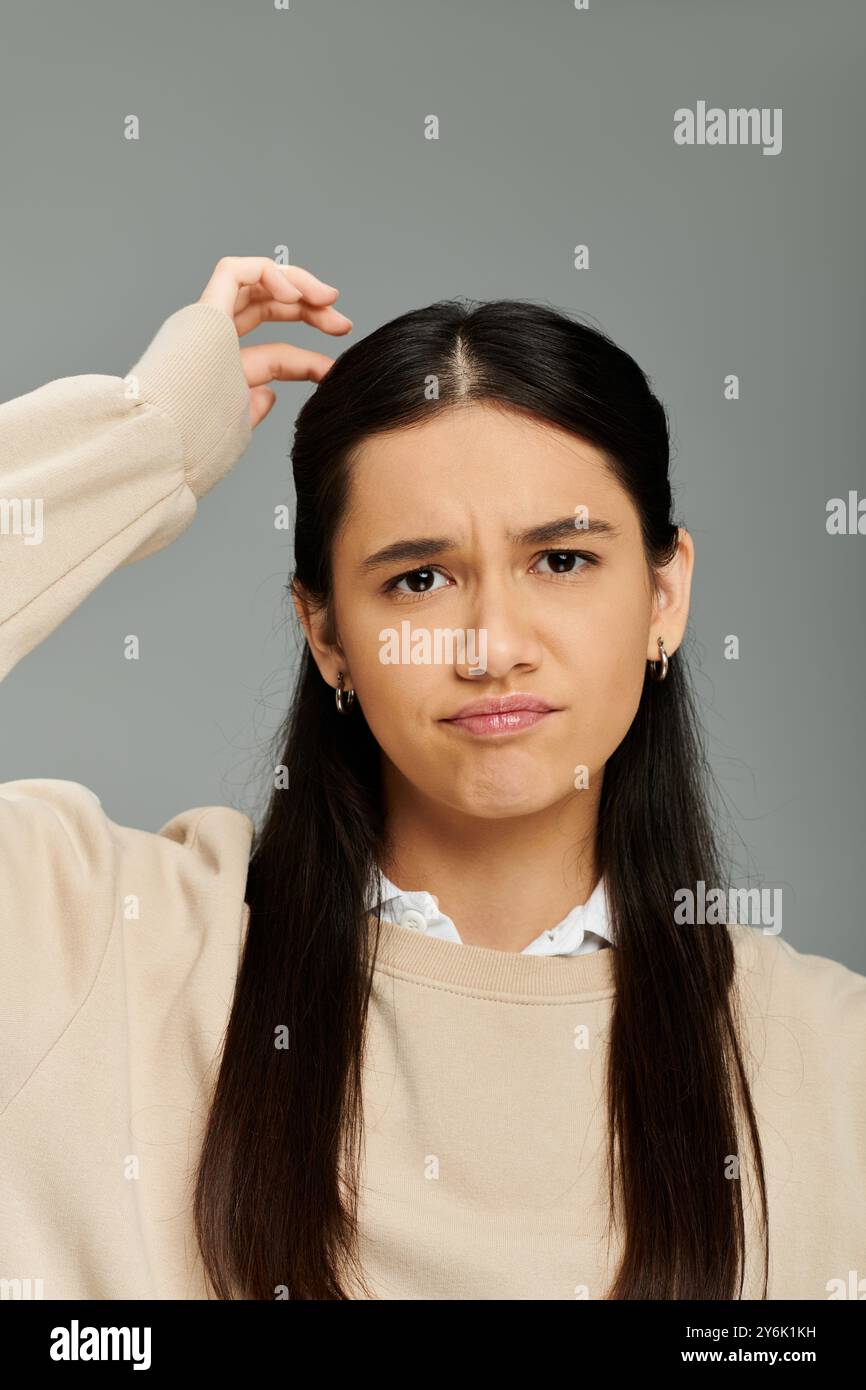A stylish young woman with long hair shows her emotions while pondering ...