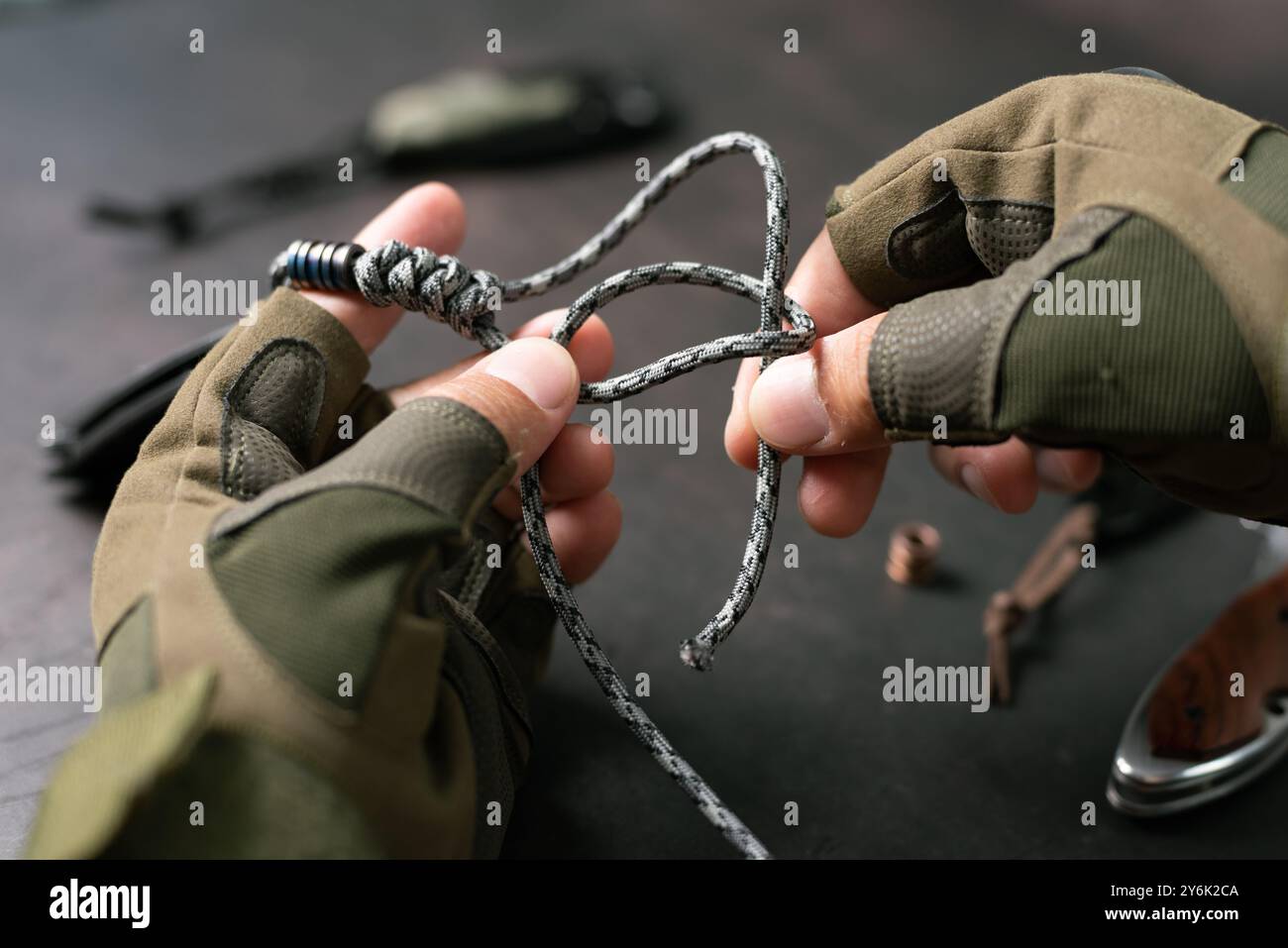 The man weaving lanyard from paracord rope and Titanium charm. Paracord ...