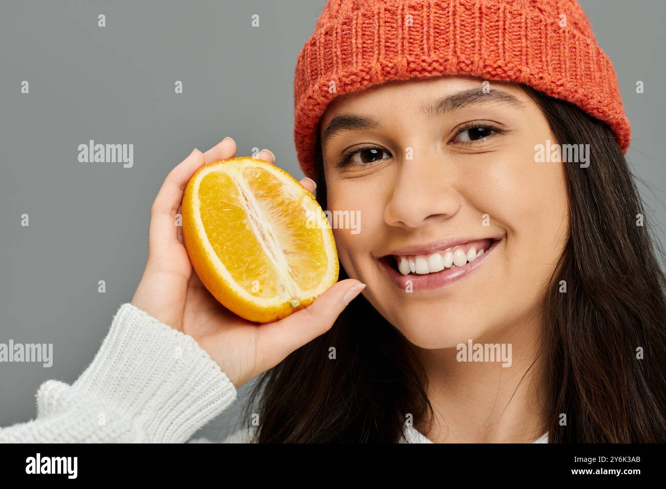 Emotional young woman radiates joy while playfully holding a fresh ...