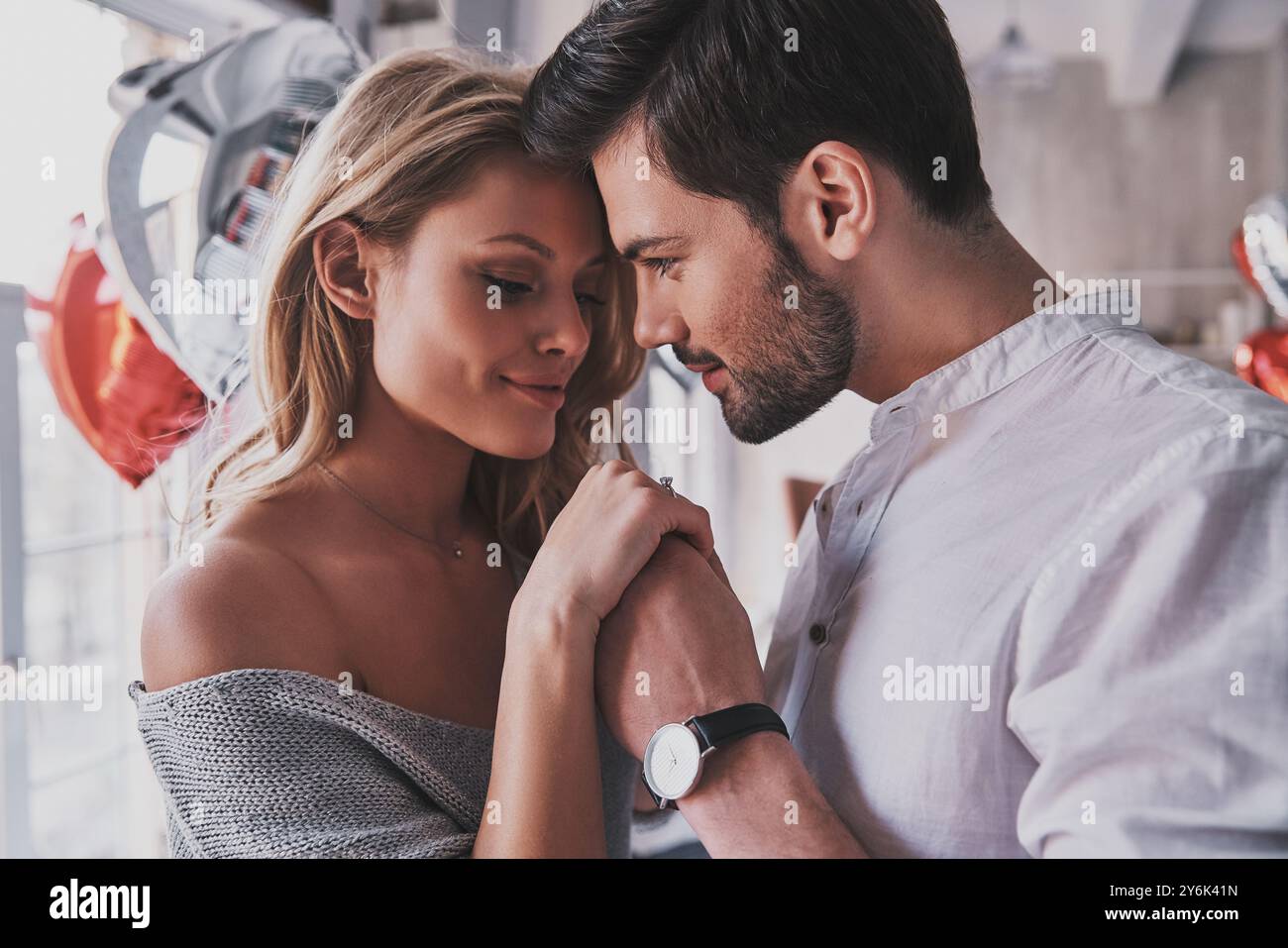 Quite moments together. Beautiful young couple holding hands while ...