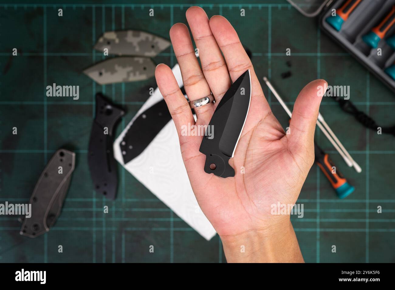 The man cleaning a pocket knife. Close up black blade on a hand. Pocket ...