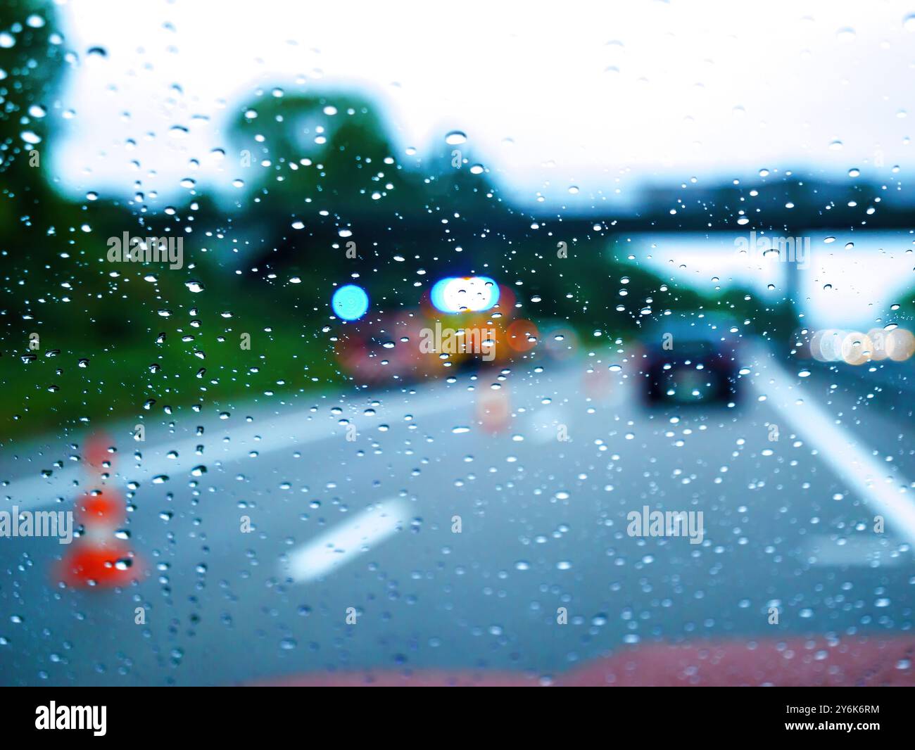 On a rainy day, cars drive on the highway as police, firefighters, or ...