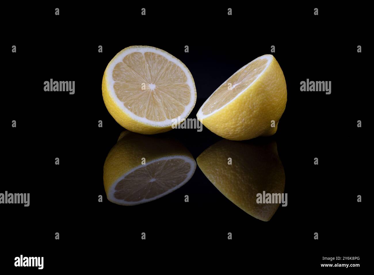 Lemon cut in half with black background and reflection Stock Photo - Alamy