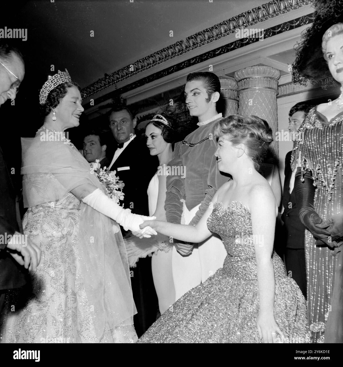Singer Marion Ryan in a shimmering strapless evening dress curtsies as ...