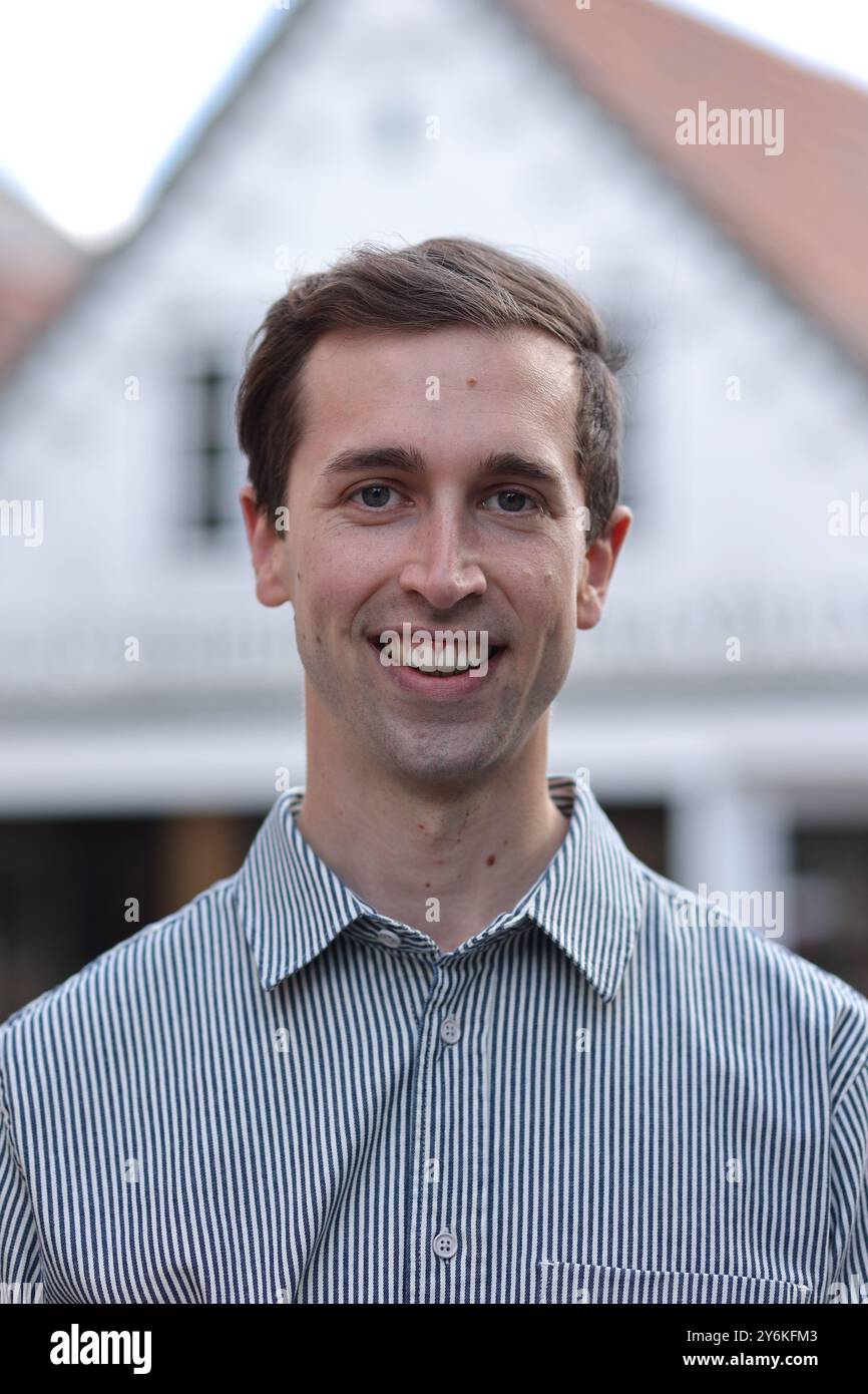 Photo of a Nordic young man smiling at the camera in Wyk city on Foehr ...