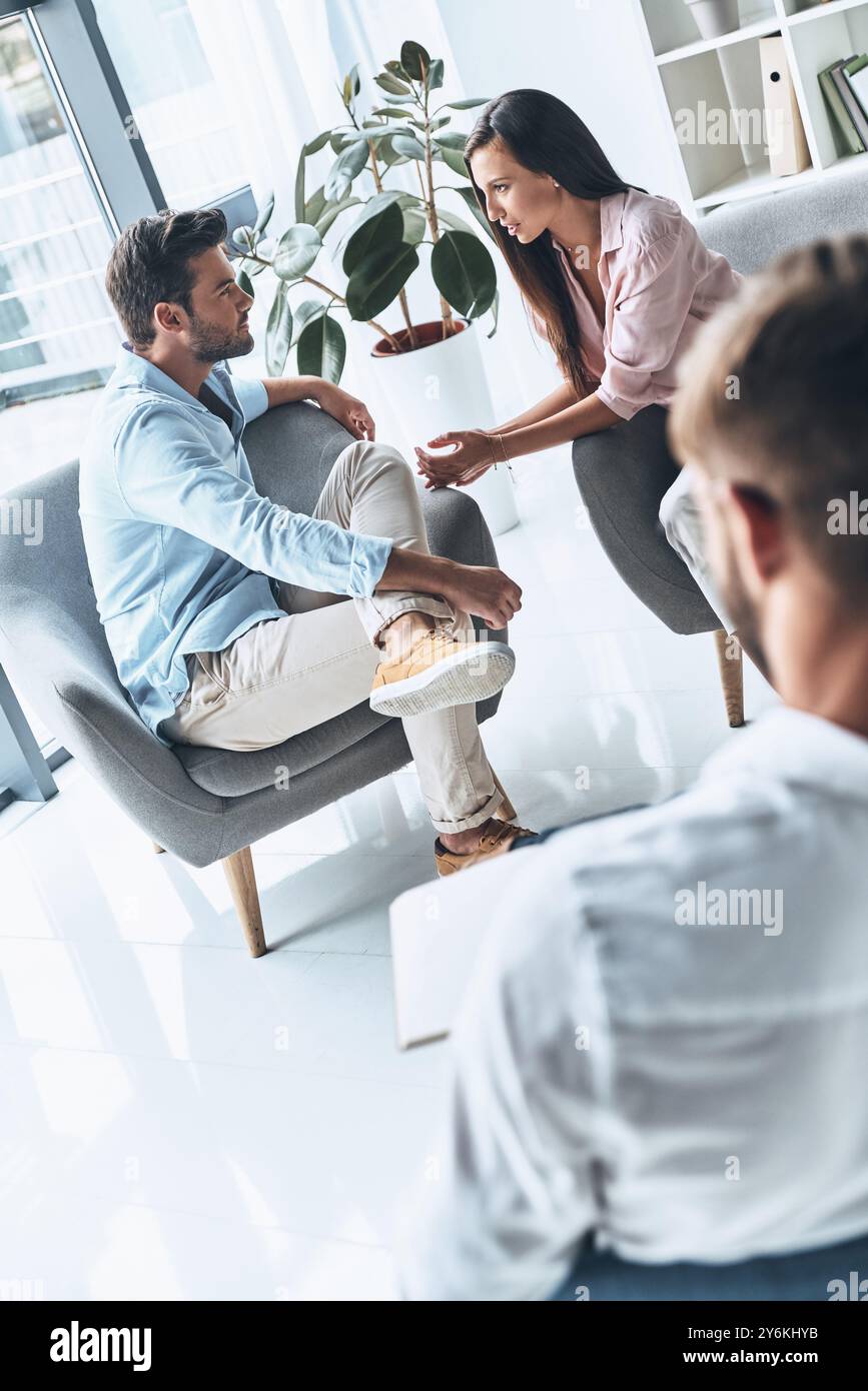 Every story has two sides. Young married couple talking while sitting ...