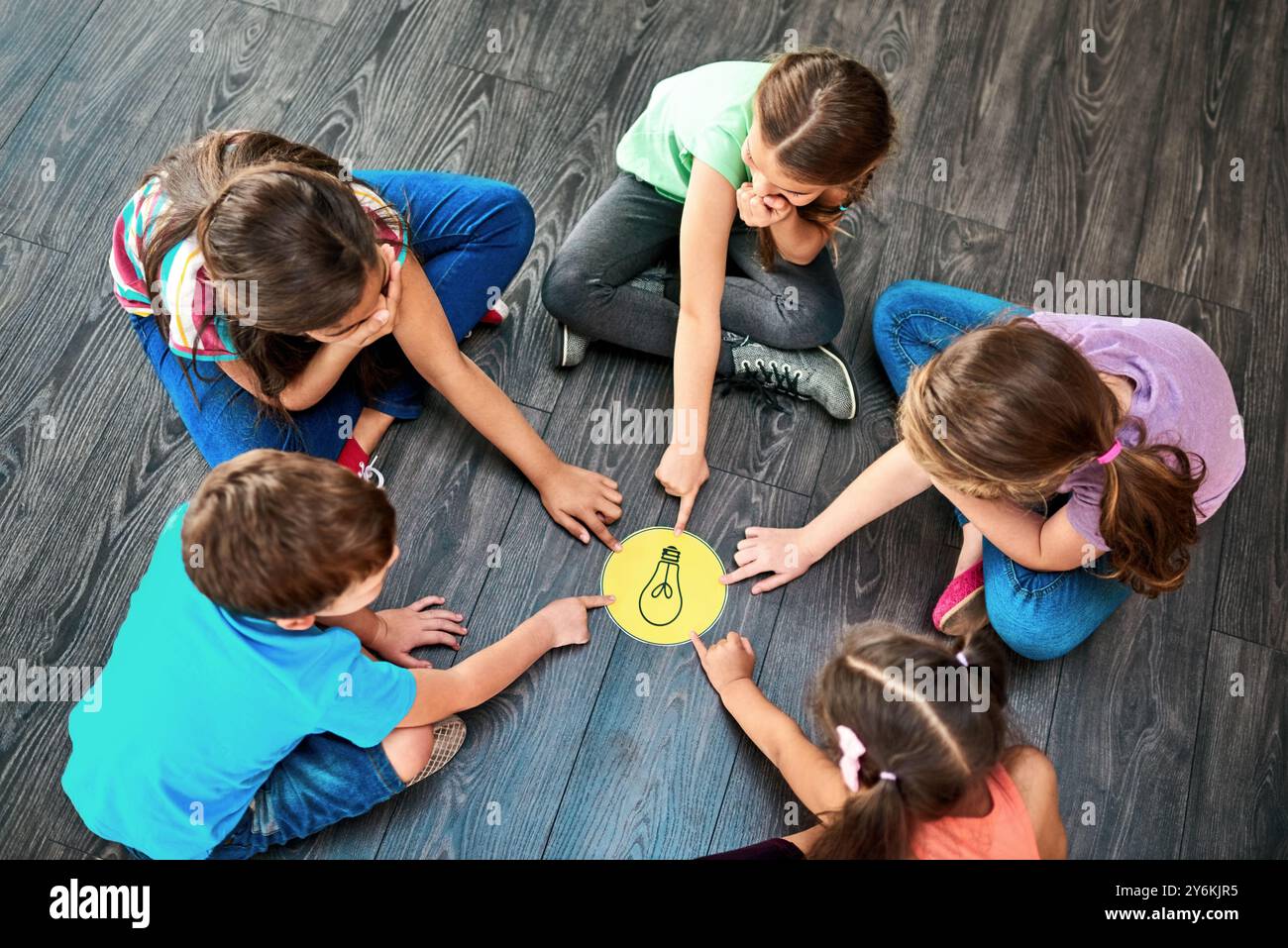 Kids, pointing and playing a game on floor with lightbulb, decision ...