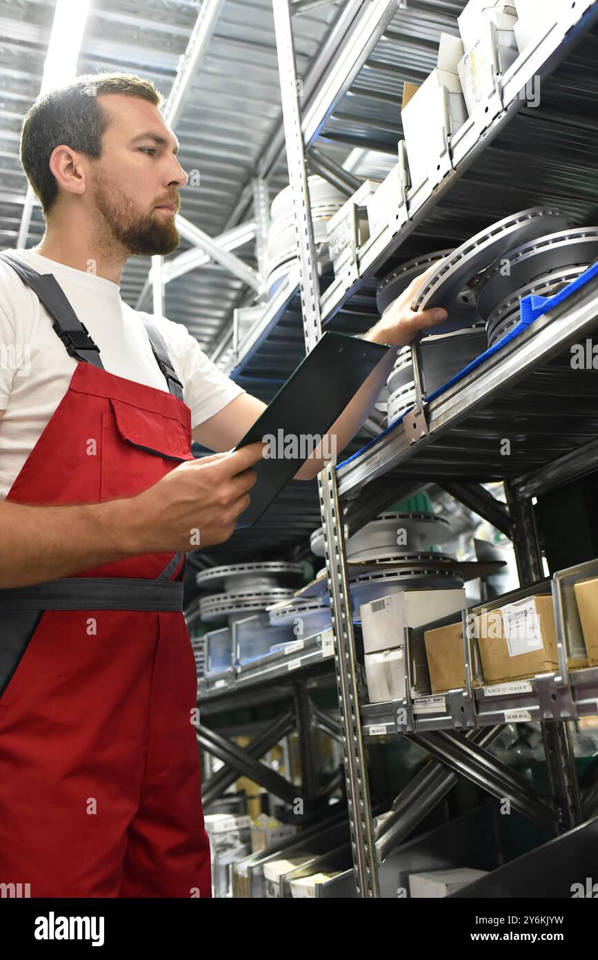 friendly worker in a warehouse and trade for car spare parts of a car ...