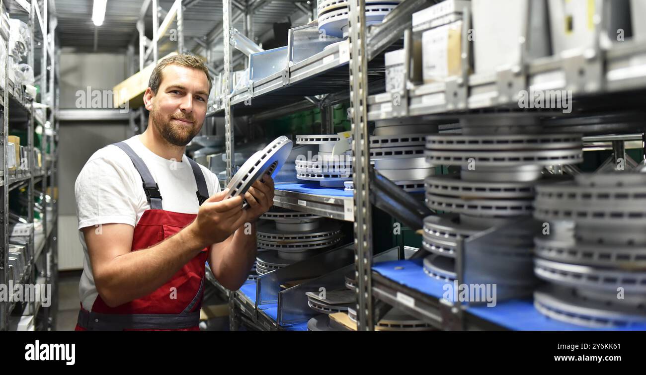 portrait friendly worker in a warehouse and trade for car spare parts ...