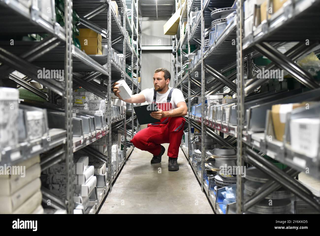 friendly worker in a warehouse and trade for car spare parts of a car ...