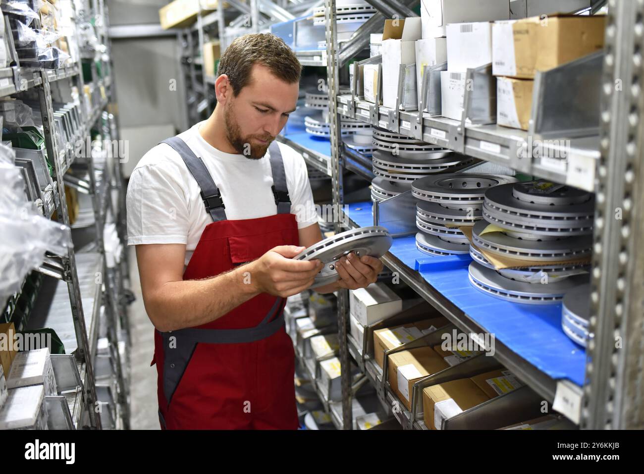 friendly worker in a warehouse and trade for car spare parts of a car ...