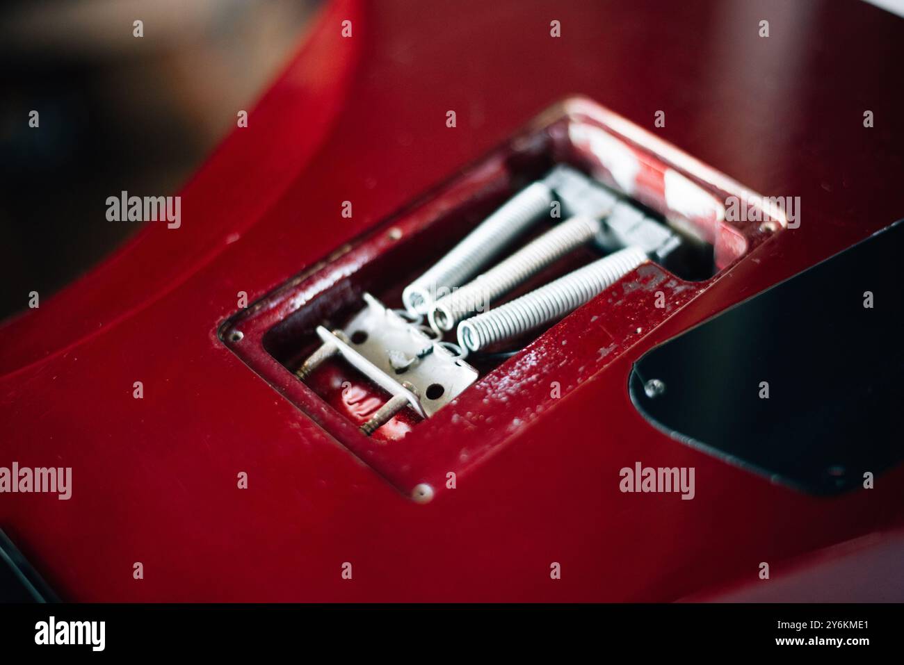Red electric guitar body on guitar repair desk or in a repair work shop ...