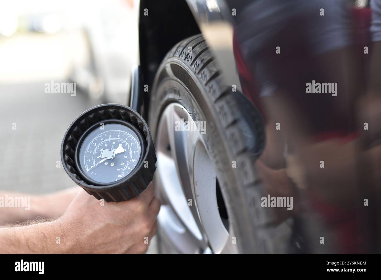 auto mechanic checks the air pressure of a tire in the garage Stock ...