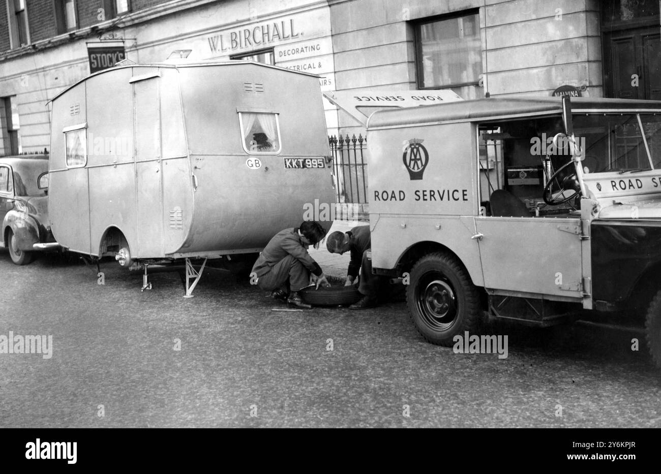 An AA Road Service jeep stopping to help fix a punctured tire on the ...