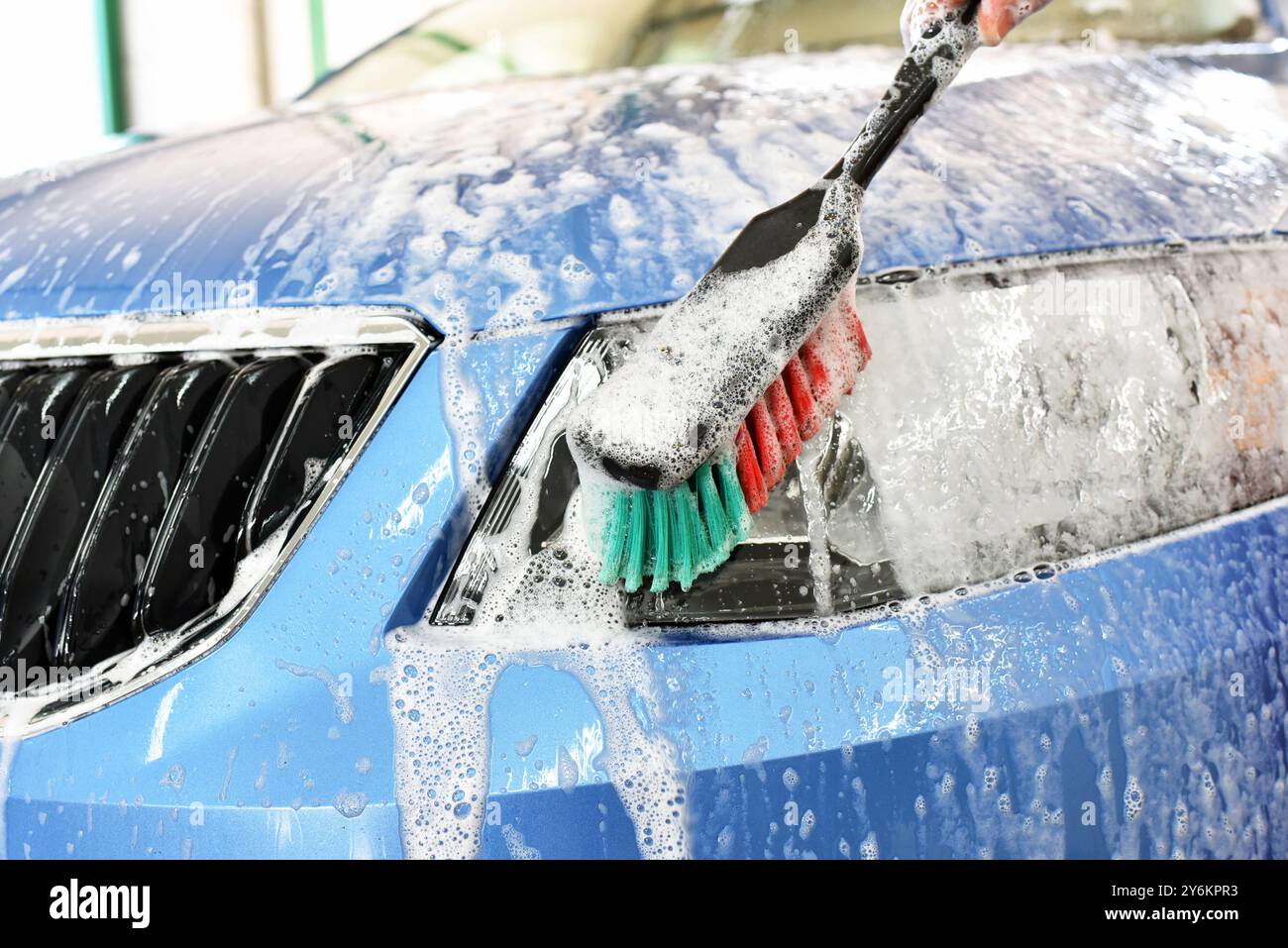 Car wash - employees of a car dealership clean a vehicle professionally ...
