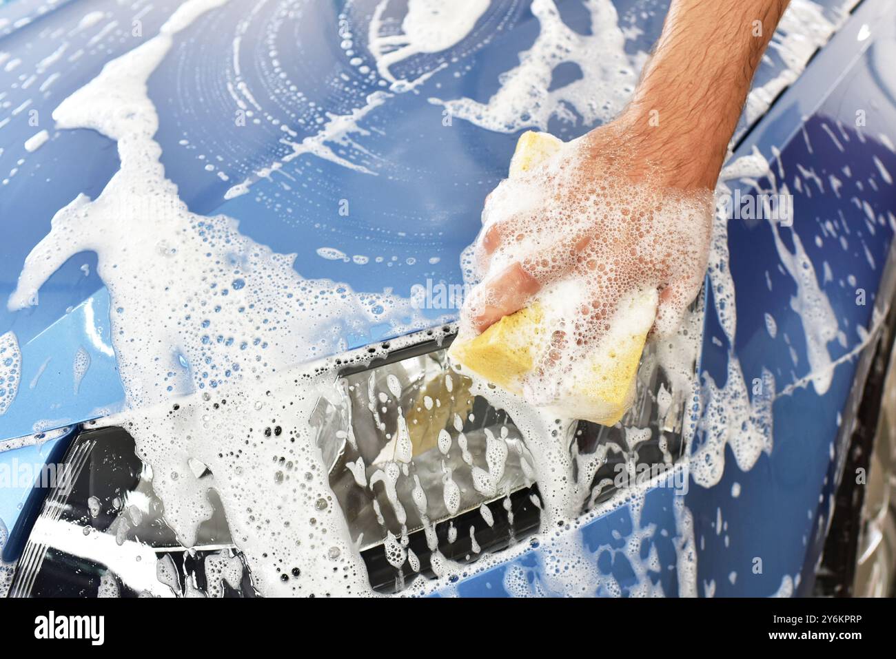 Car wash - employees of a car dealership clean a vehicle professionally ...