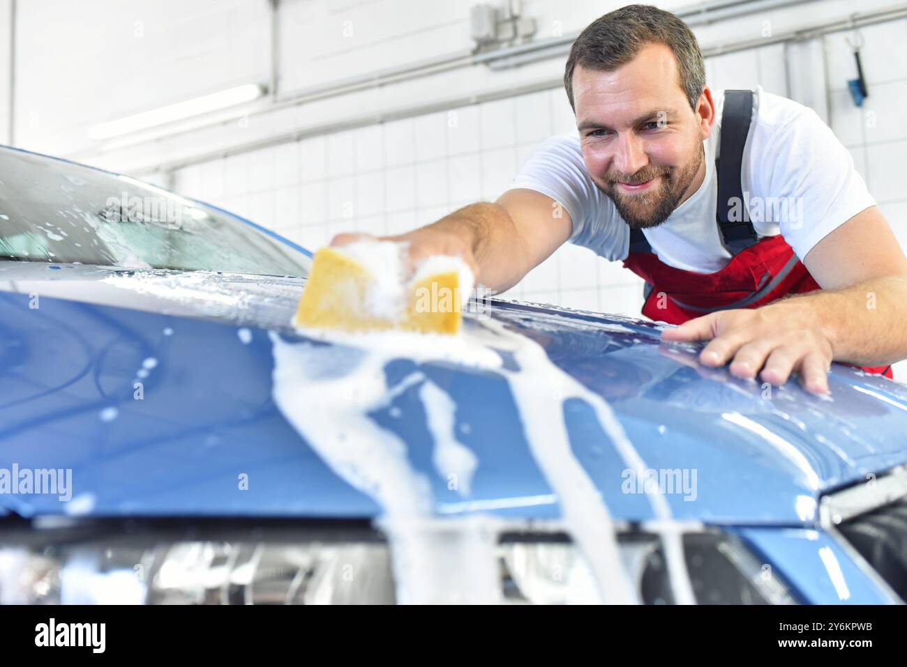 Car wash - employees of a car dealership clean a vehicle professionally ...