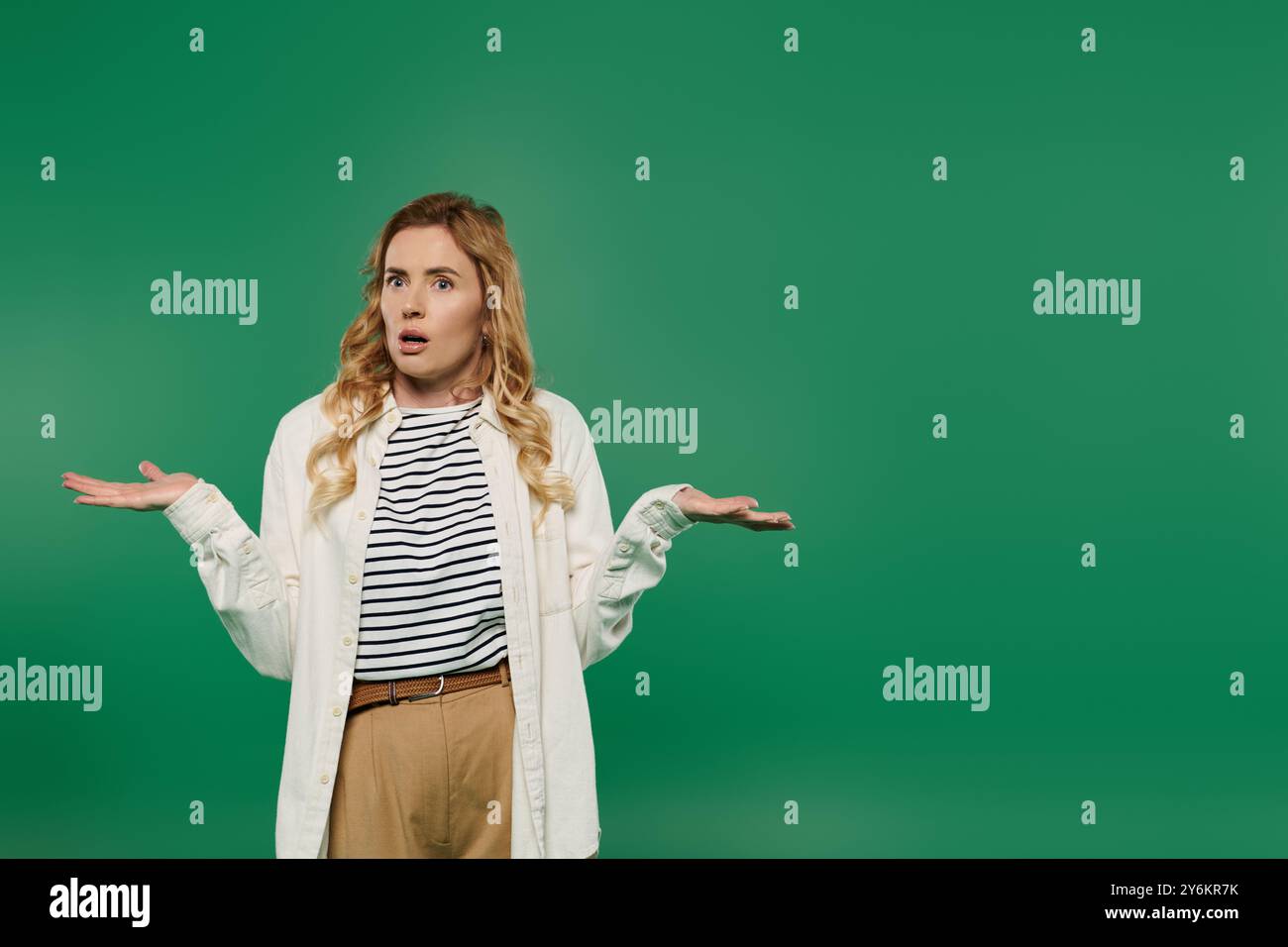 A stylish woman with curly locks shows a surprised expression while ...