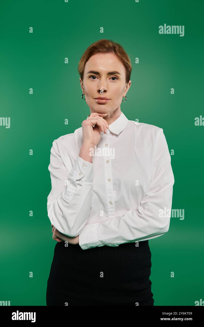 A confident woman in a white shirt stands poised with her hand on her ...