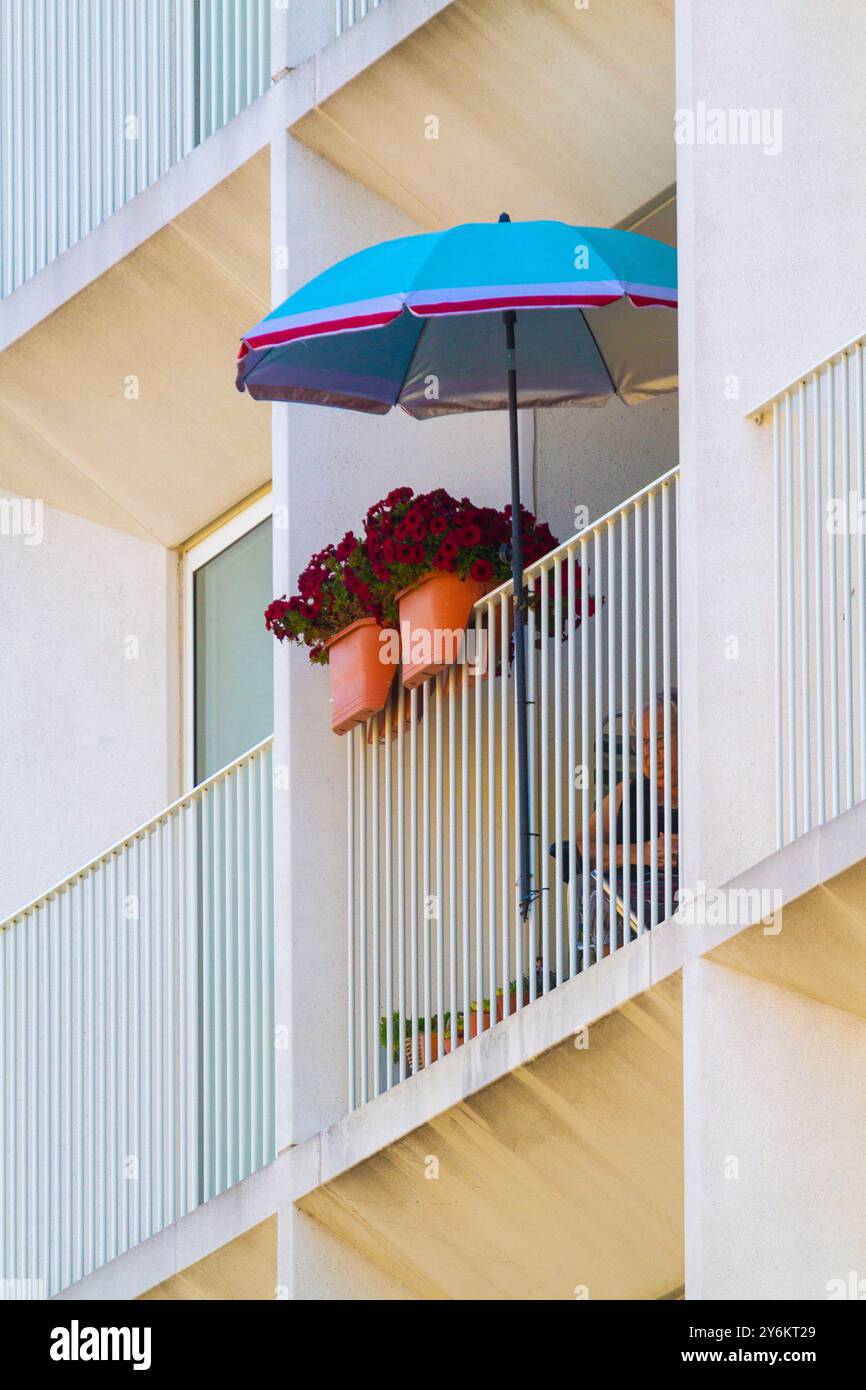 Building balcony with plant and parasol Stock Photo - Alamy