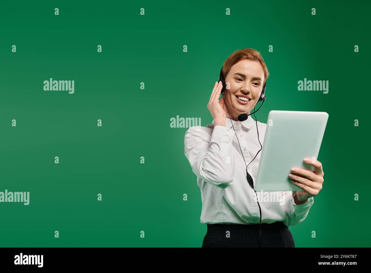 A professionally dressed woman interacts with clients using a tablet ...
