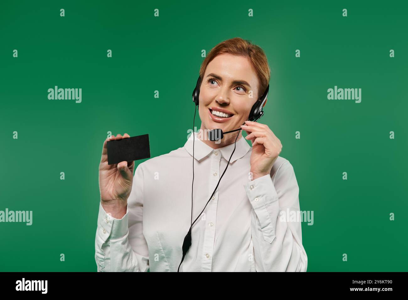 A professional woman smiles while holding a device, ready to assist ...