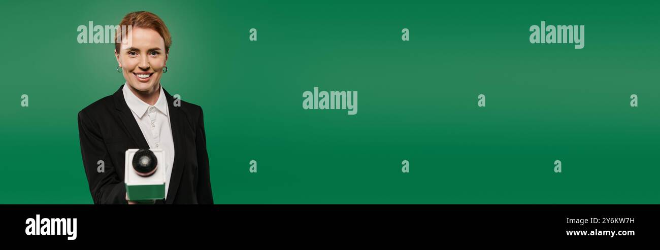 A poised TV presenter in black formal attire interacts with the camera ...