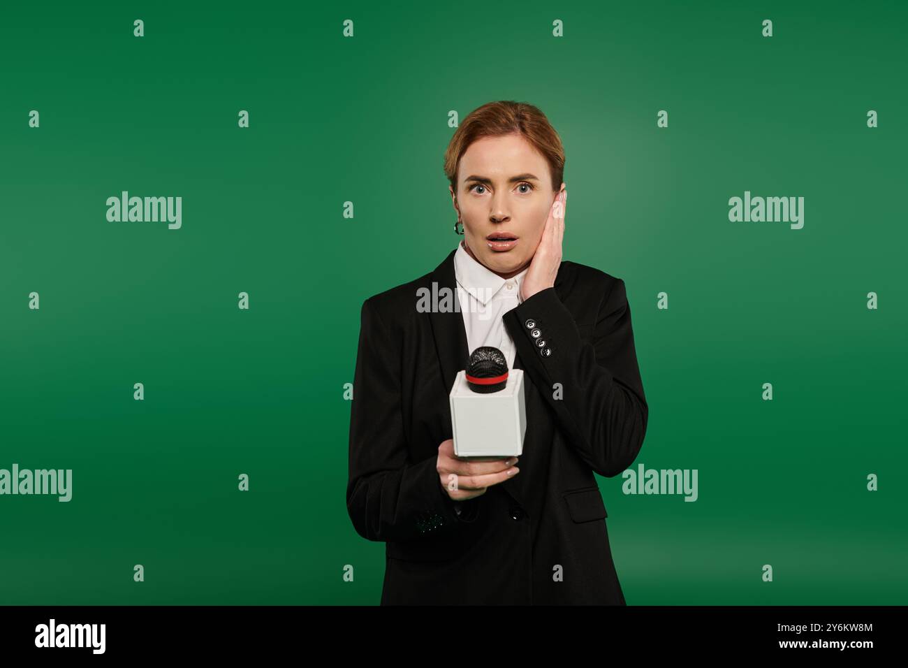 A TV presenter, dressed elegantly in black, reacts with surprise while ...