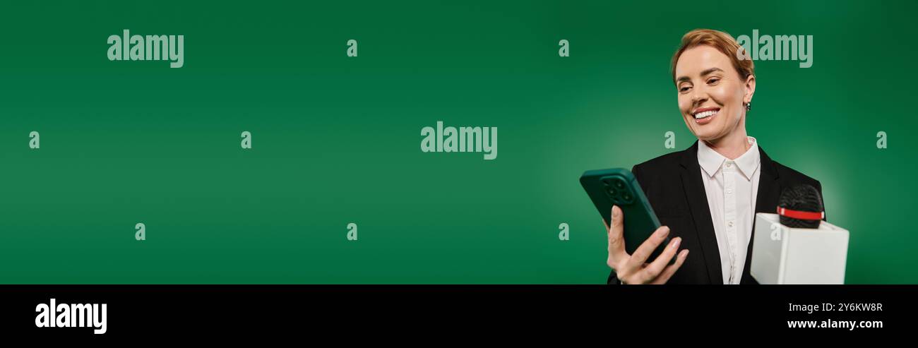 A captivating TV presenter standing with smartphone and microphone on a ...