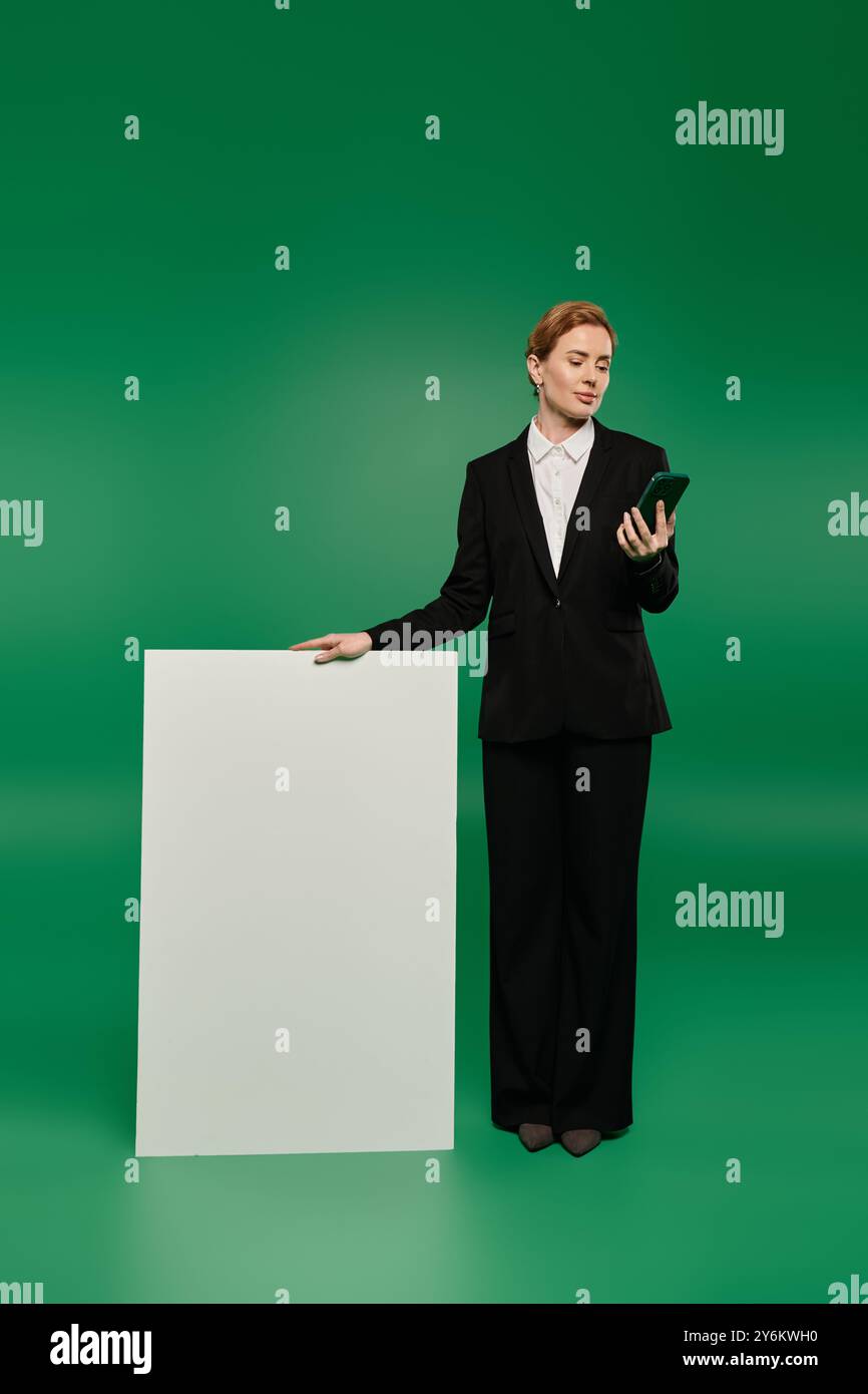 A stylish TV presenter in black holds a smartphone, poised to engage ...