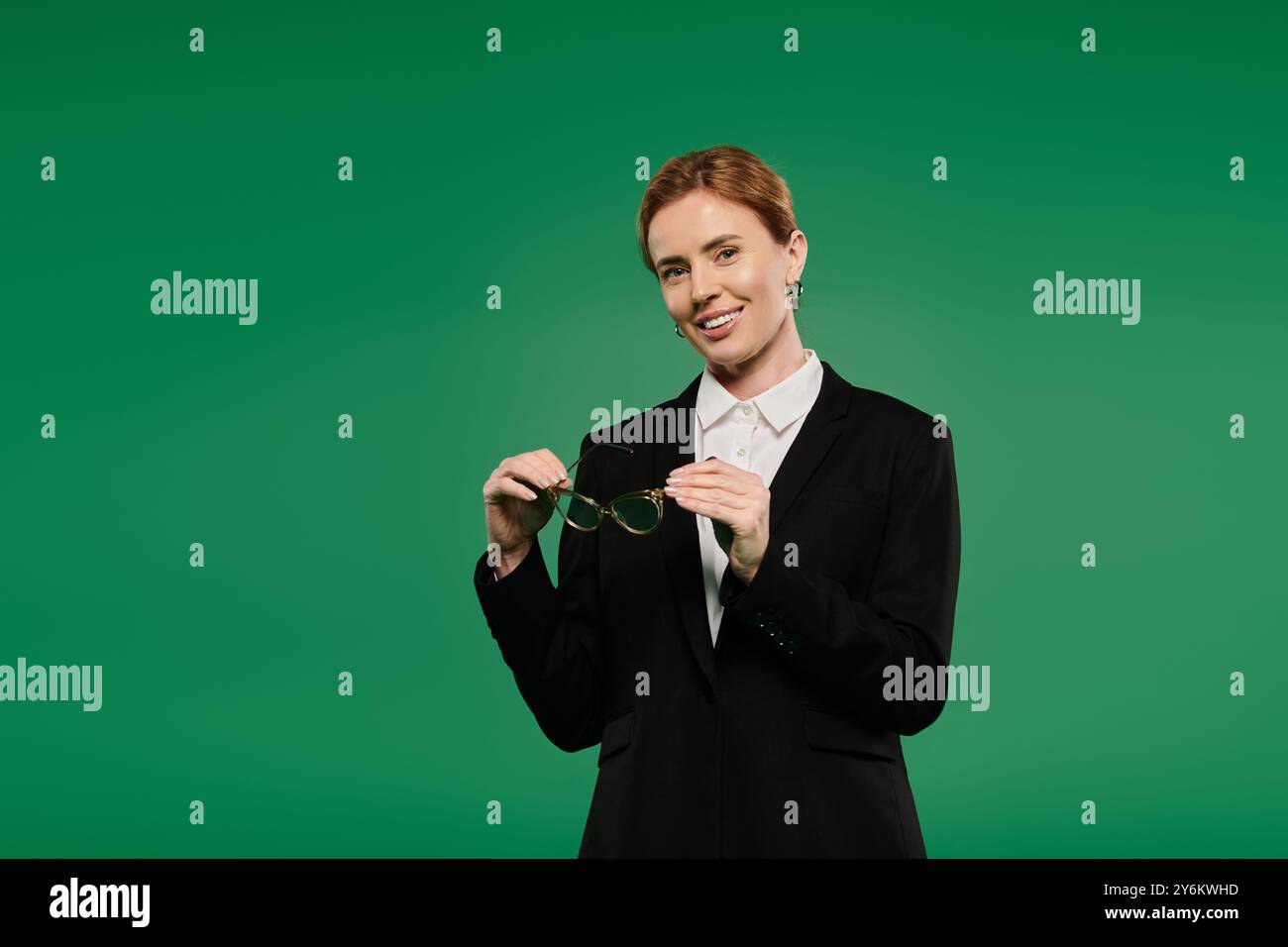 Dressed in formal black, a TV presenter showcases a warm smile while ...