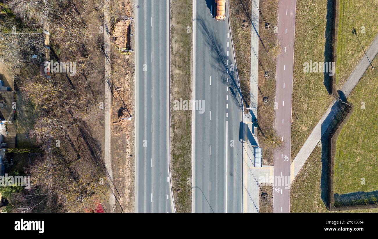 Aerial view of a car driving on a divided road with a grassy median ...
