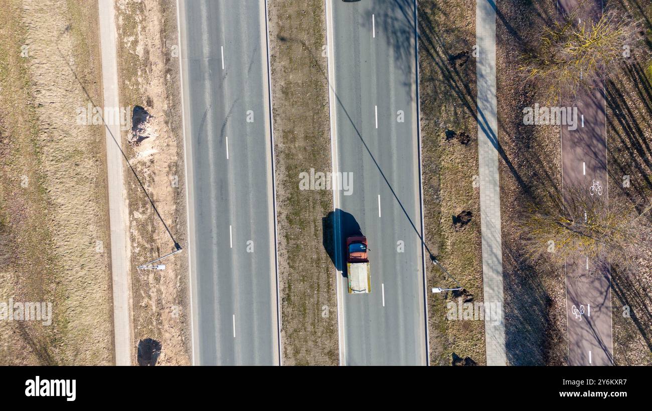 Aerial view of a car driving on a divided road with a grassy median ...