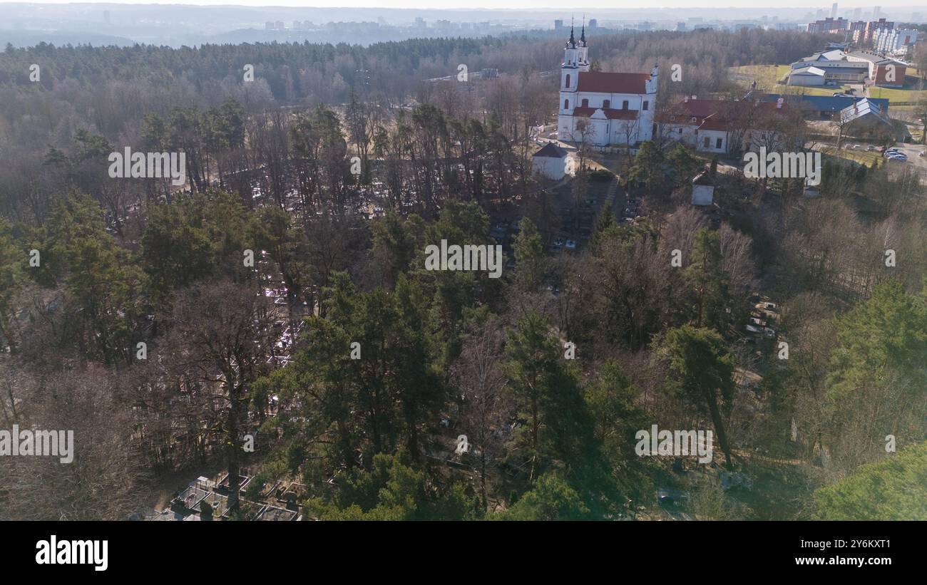 Aerial view of a cemetery surrounded by tall trees. The graves are ...