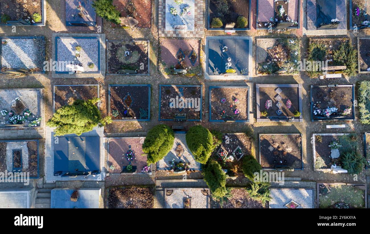 Aerial view of a cemetery surrounded by tall trees. The graves are ...