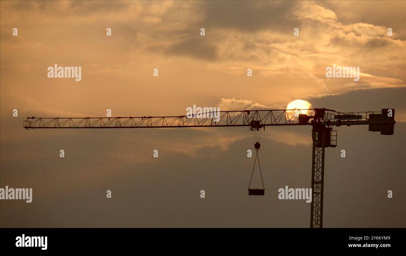 Zoom in to a construction crane with the sun behind Stock Photo - Alamy