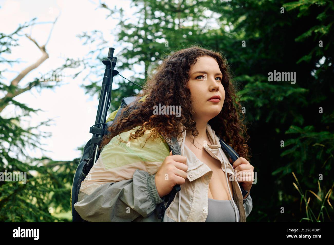 A confident plus size woman enjoys a peaceful moment in a lush forest ...