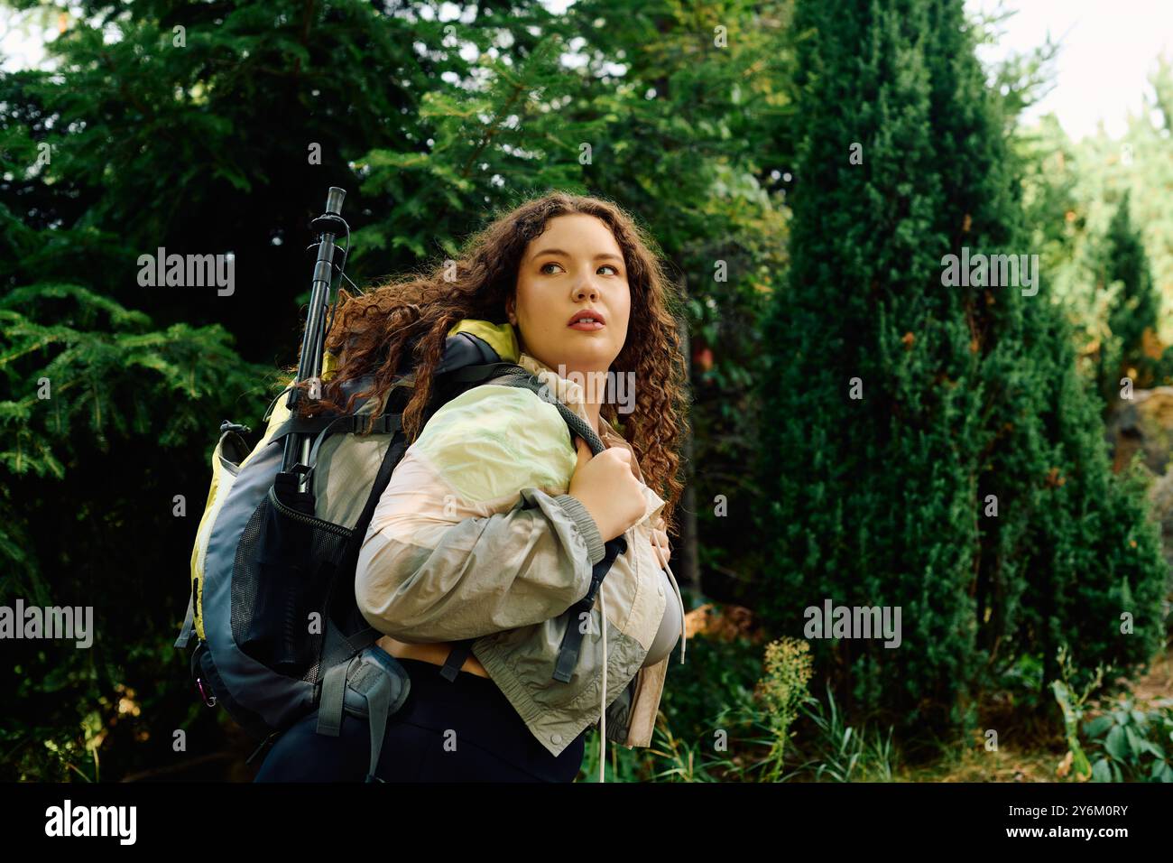 A plus size woman with curly hair is immersed in nature, exploring a ...